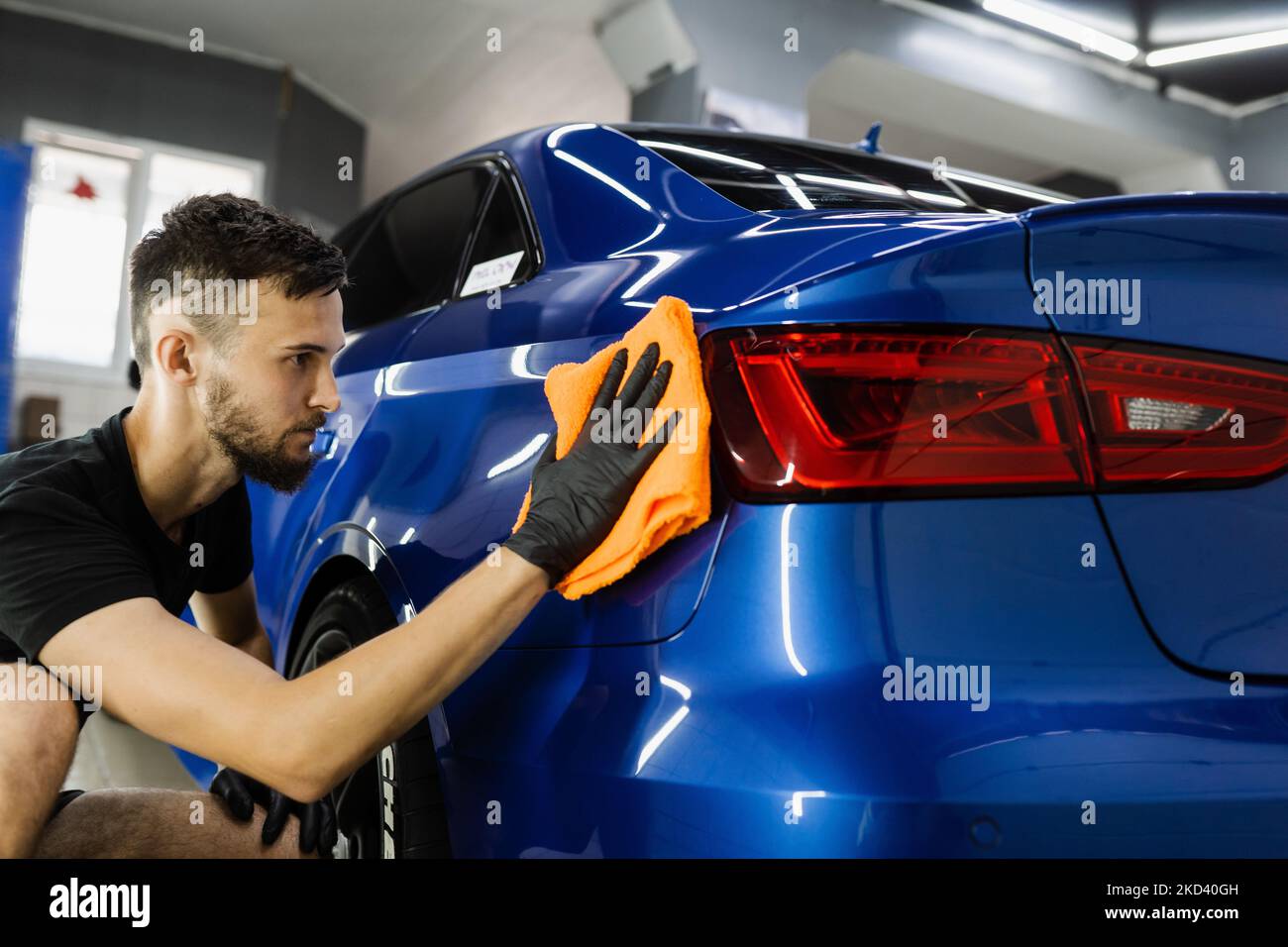 Cleaner man worker dry body car after washing automobile. Hand car ...