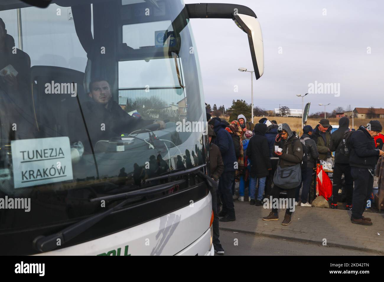 People fleeing from Ukraine are seen standing by a bus after crossing ...