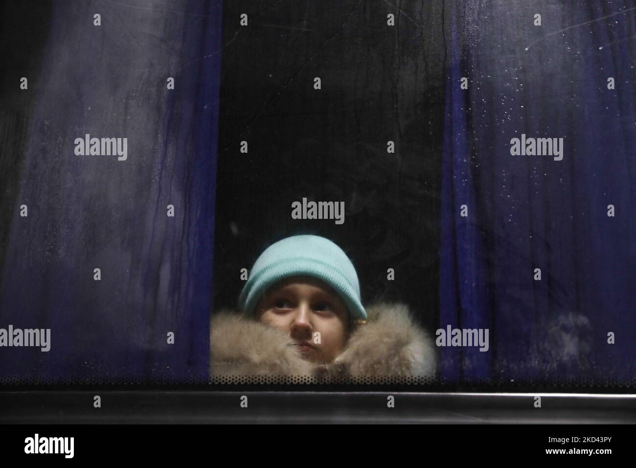 A girl fleeing from Ukraine arrives by bus to a parking lot in Przemysl ...