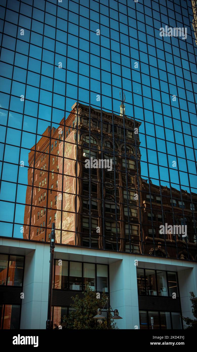 Old building reflected on the glass wall of a modern skyscraper ...
