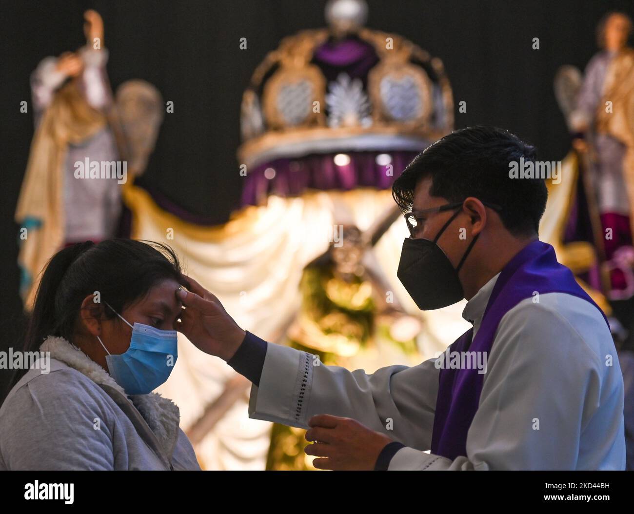 The priest makes the sign of the cross with ashes on the head of the ...