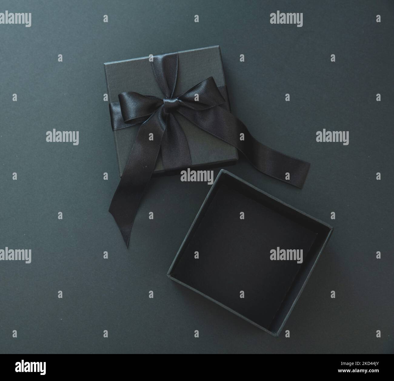 Black Friday sale concept, Gift box open with ribbon bow against black ...