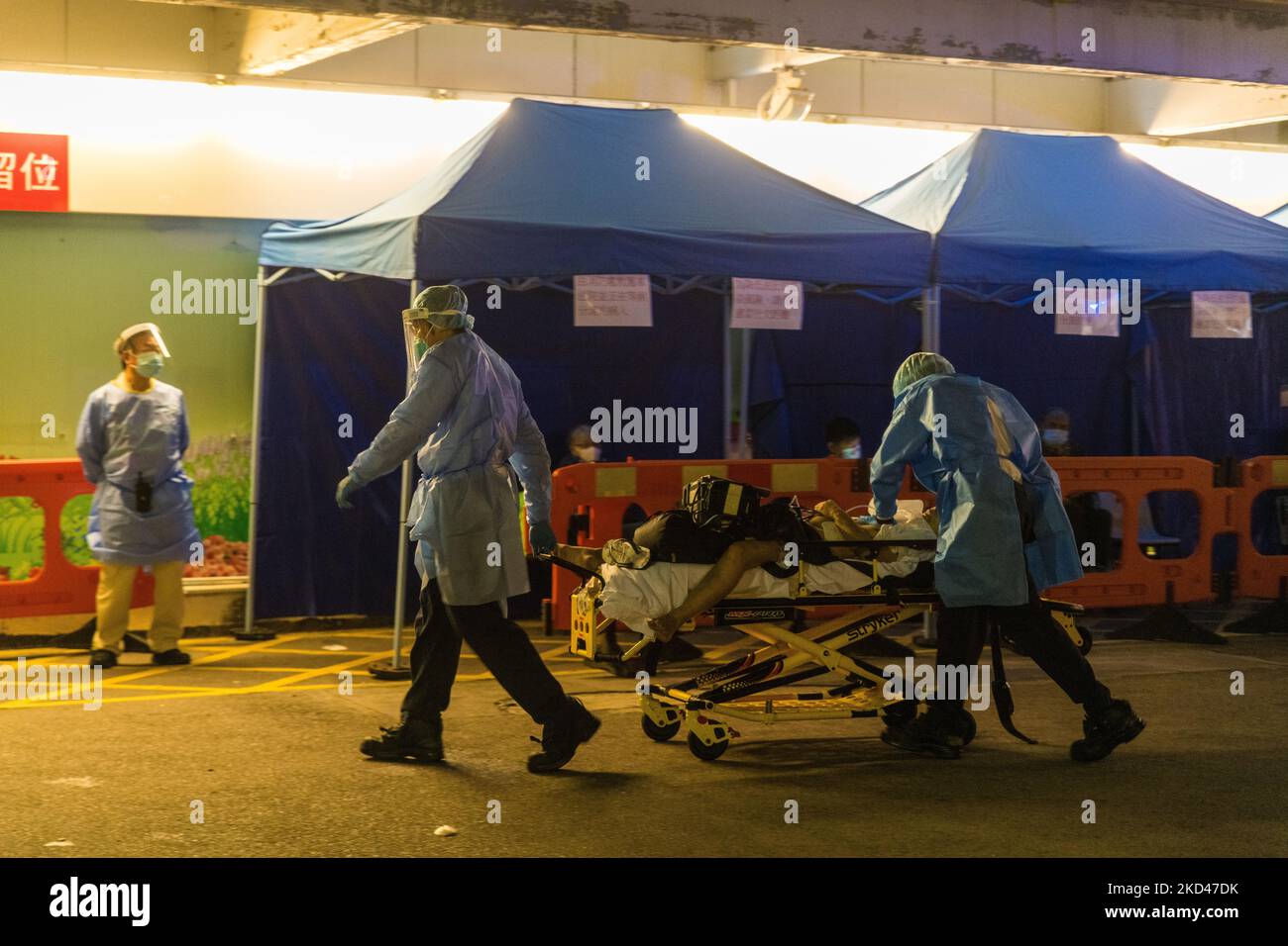 Paramedics in PPE perform CPR on a patient in cardiac arrest at the ...