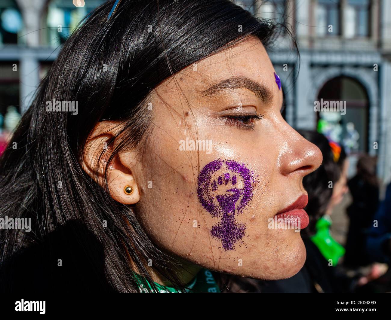A woman has her face painting with the female sign, during the Women's ...
