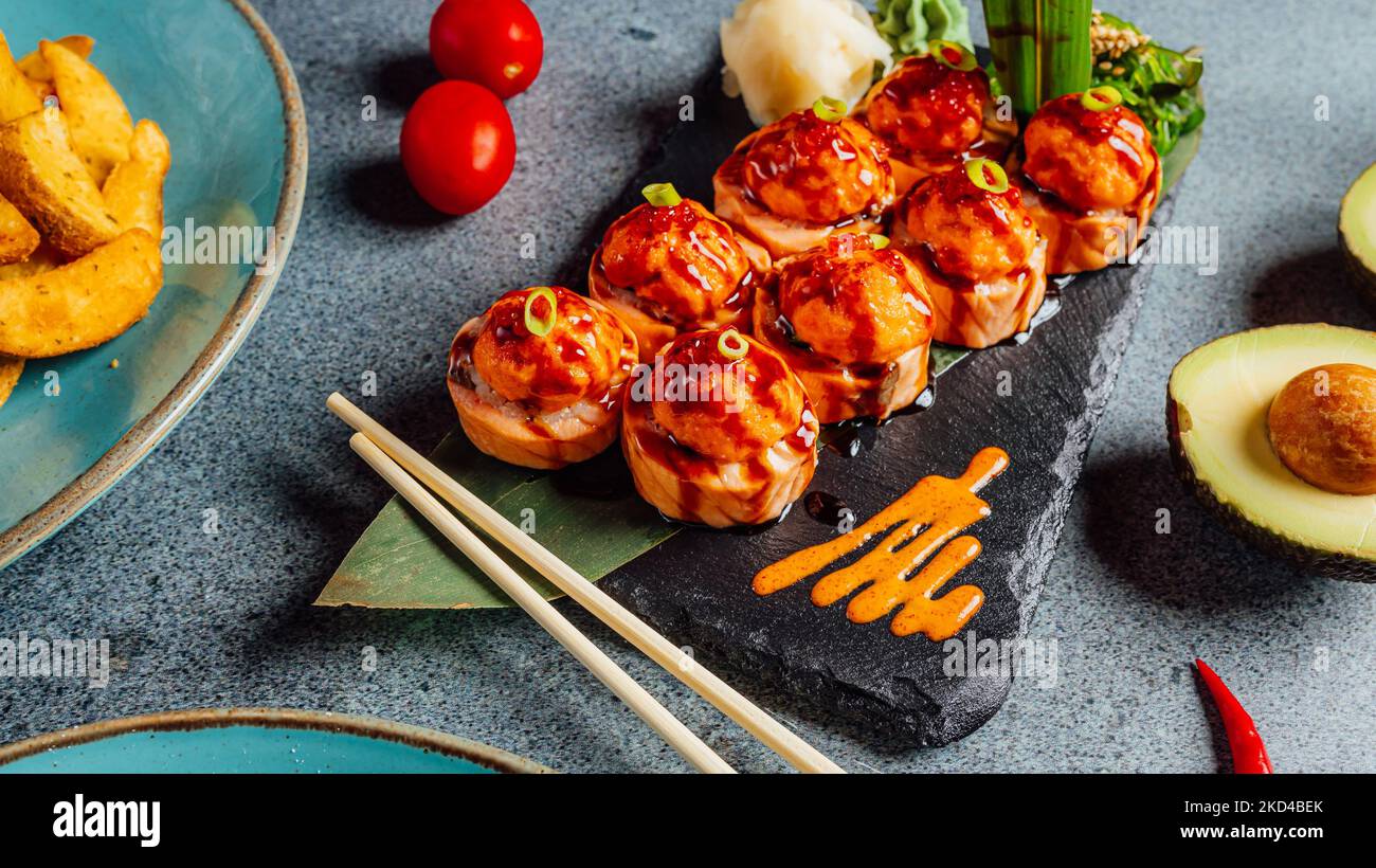 A delicious Takoyaki dish served on a stone with wooden chopsticks ...