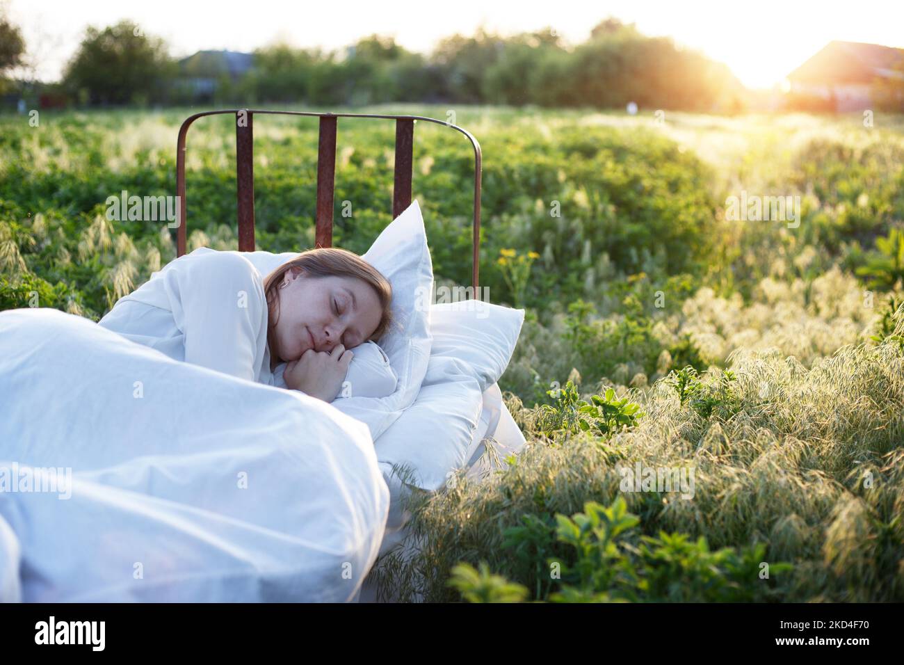 girl sleeping in the bed in a green field. healthy sleep in nature ...