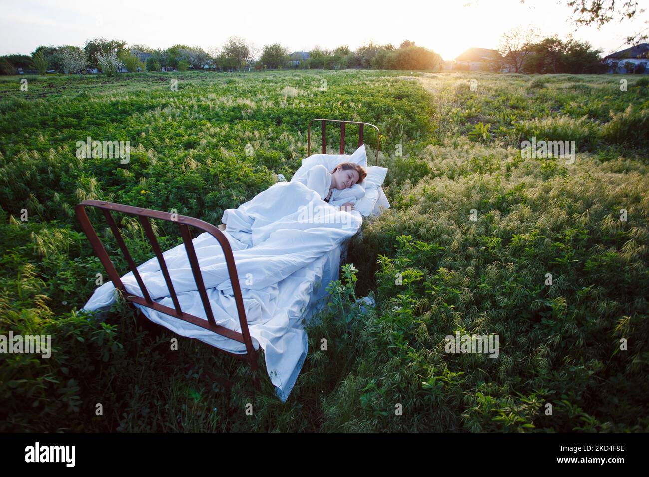 girl sleeping in the bed in a green field. healthy sleep in nature ...