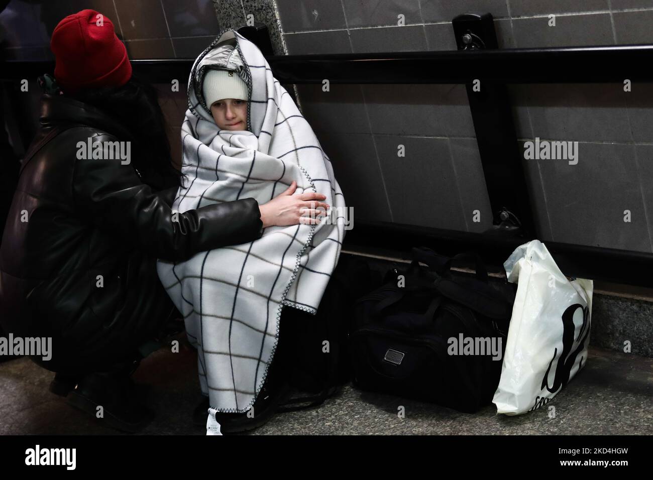 A girl sits at the train station where people fleeing from Ukraine ...