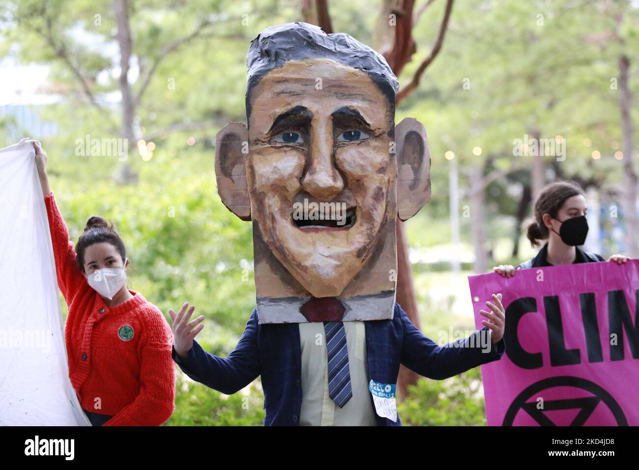 A climate activist wears a large John Kerry mask outside the CERAweek ...