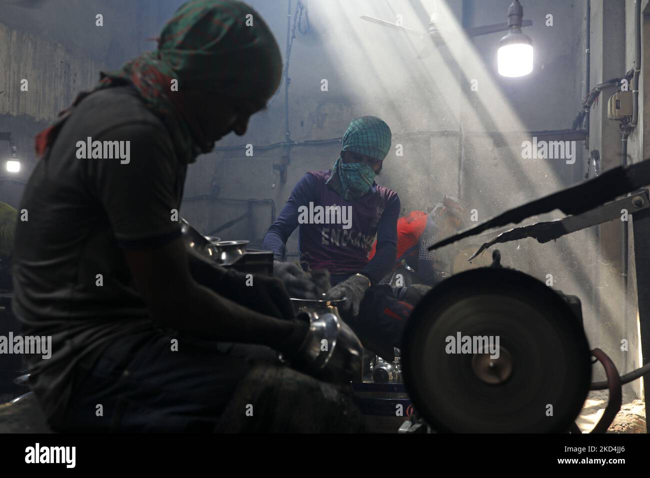 Worker works in dust environment inside in a utensil factory while ...