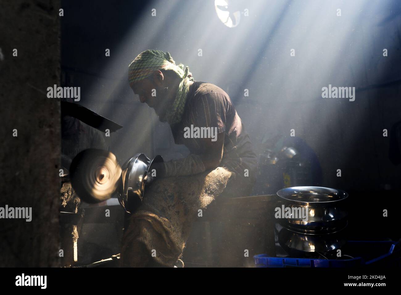 Worker works in dust environment inside in a utensil factory while ...