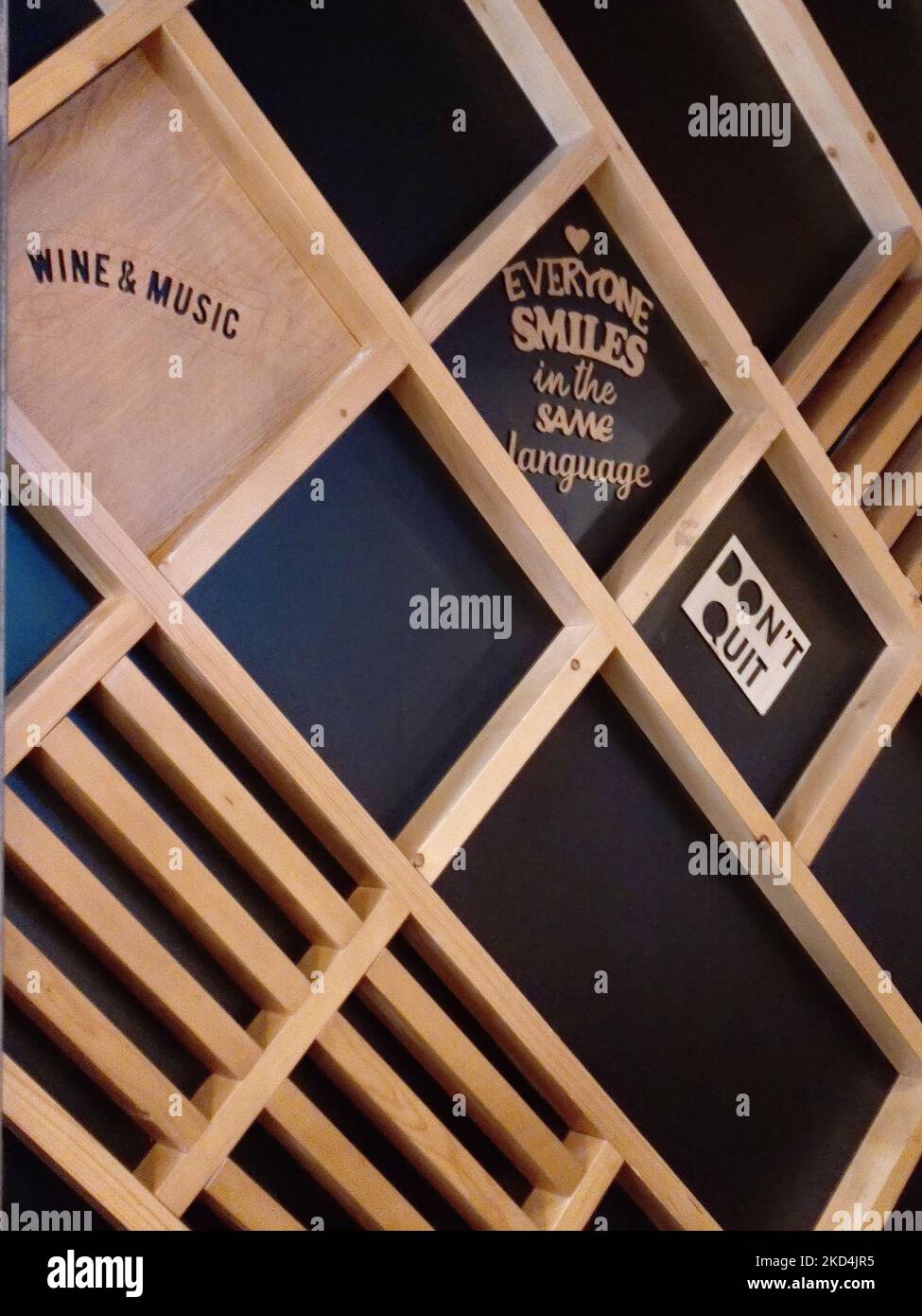 A vertical shot of wooden panels on a black wall with motivational ...