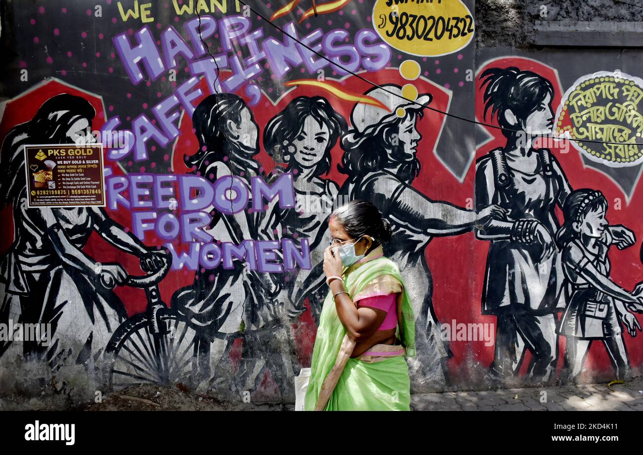 Woman passes by a wall graffiti painting of women on the day of ...