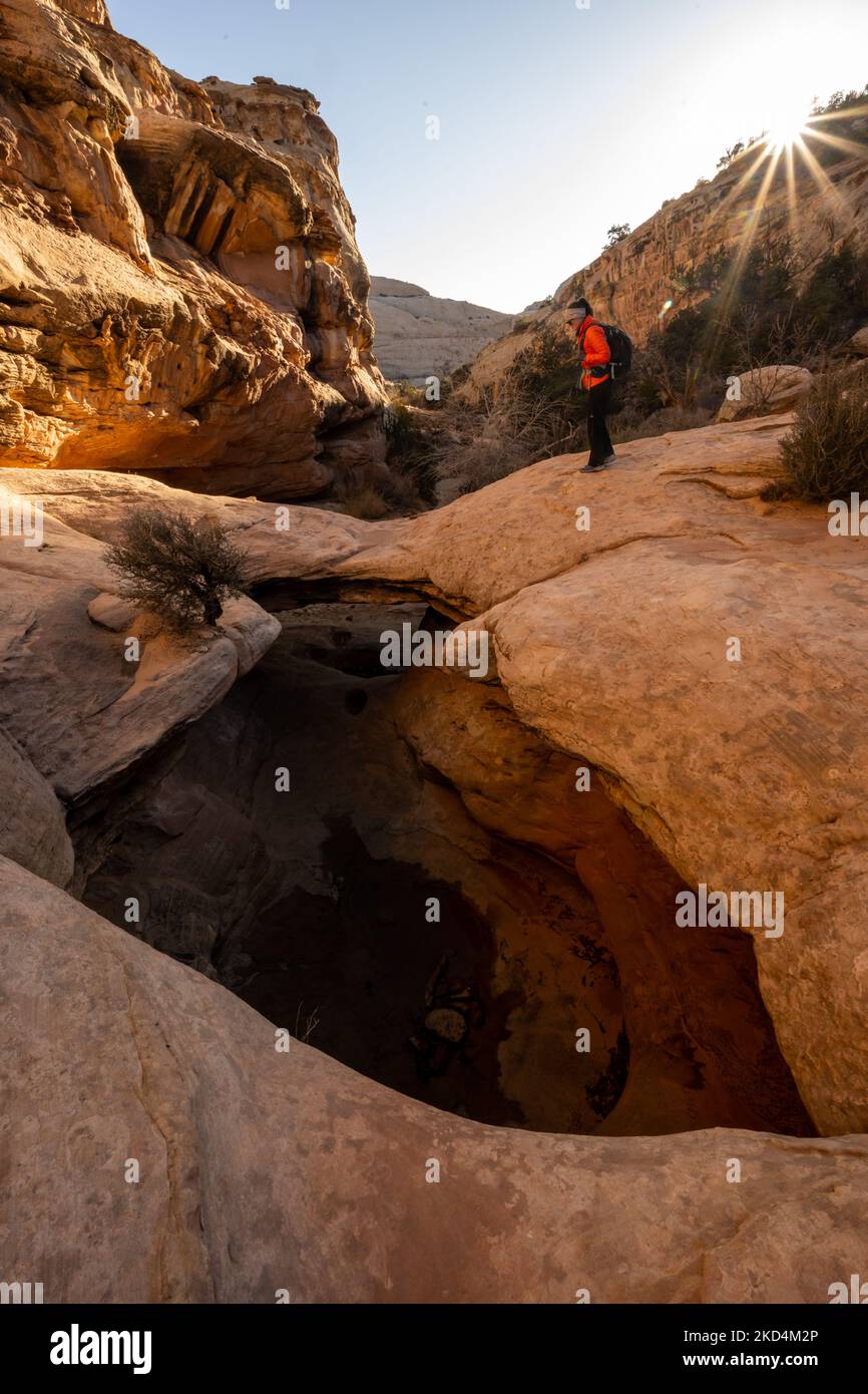 Female Hiker Looks Down Into A Small Dry Fall Pool in Capitol Reef ...