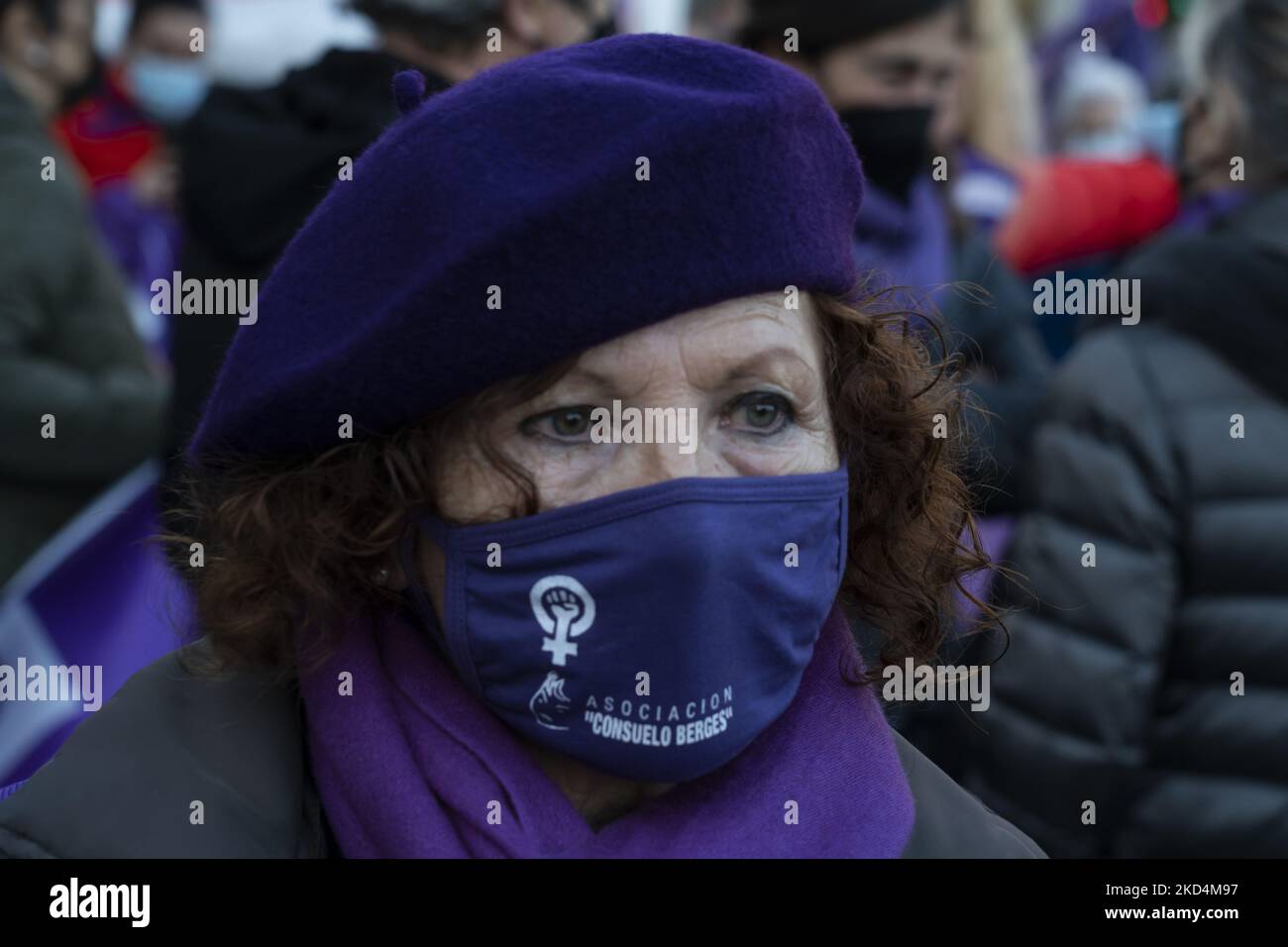 A woman dressed in the colors of feminists (purple) participates in the ...