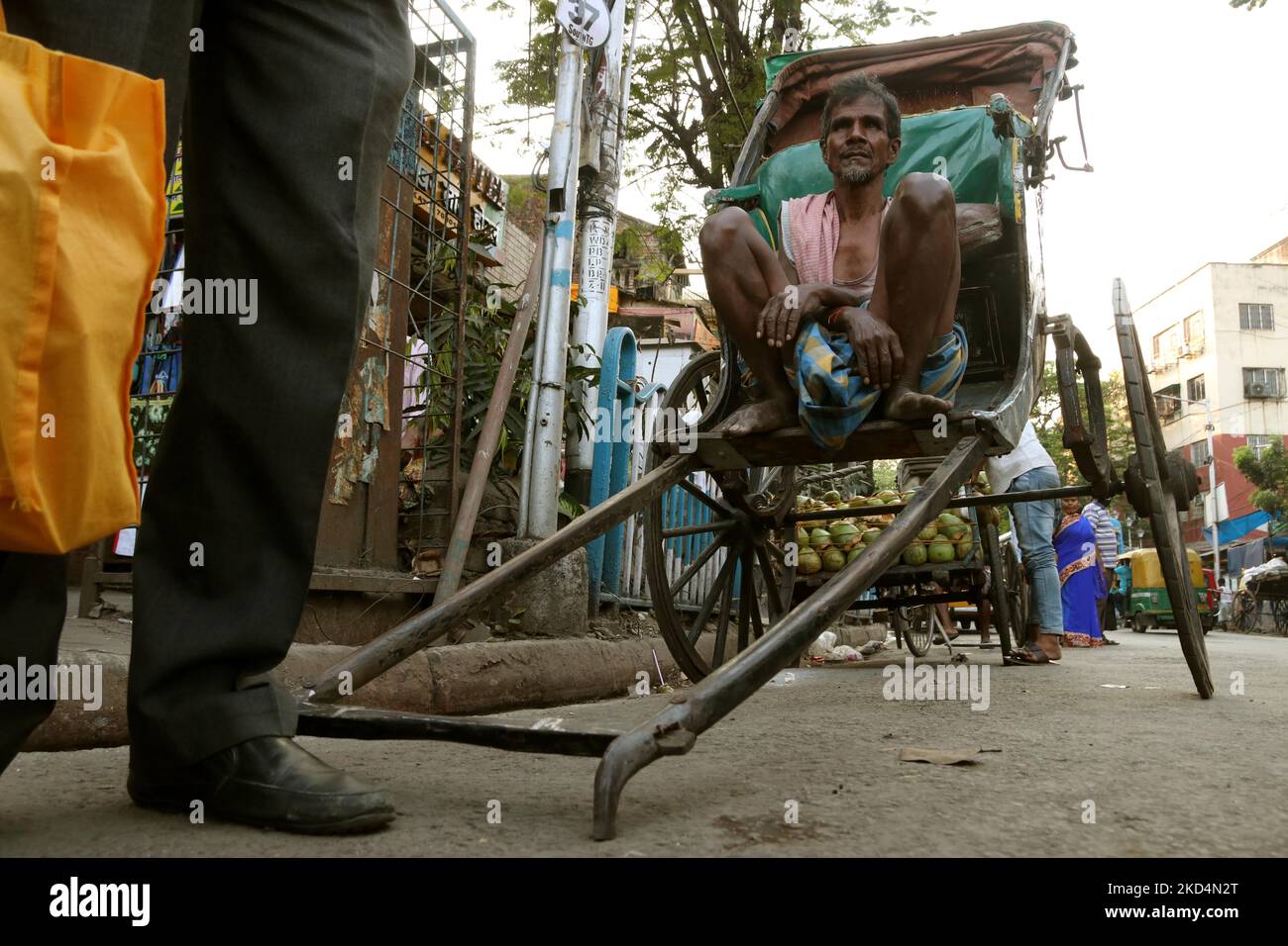 Hand-pulled rickshaw puller waiting for customer on the street side ...