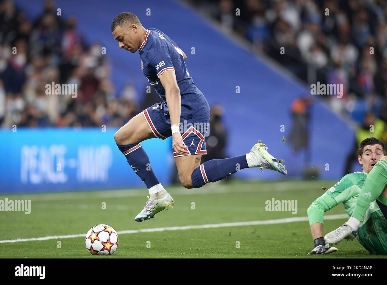 Kylian Mbappe of PSG and Thibaut Courtois of Real Madrid compete for ...