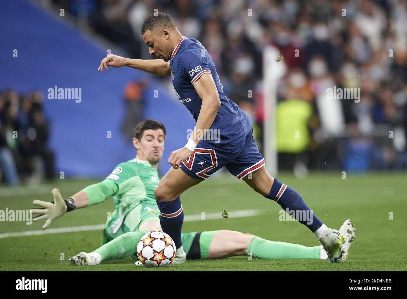 Kylian Mbappe of PSG and Thibaut Courtois of Real Madrid compete for ...