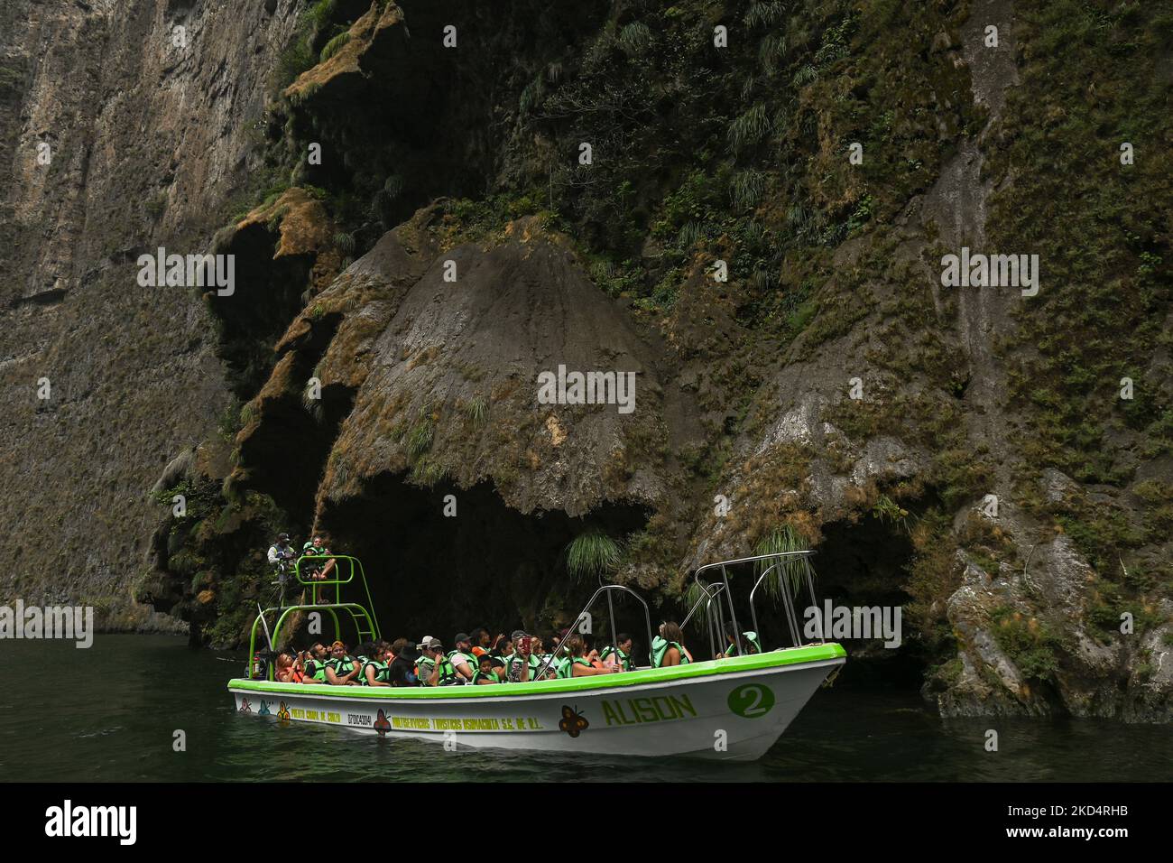 A tour boat passes close to the Christmas Tree Formation in Sumidero ...