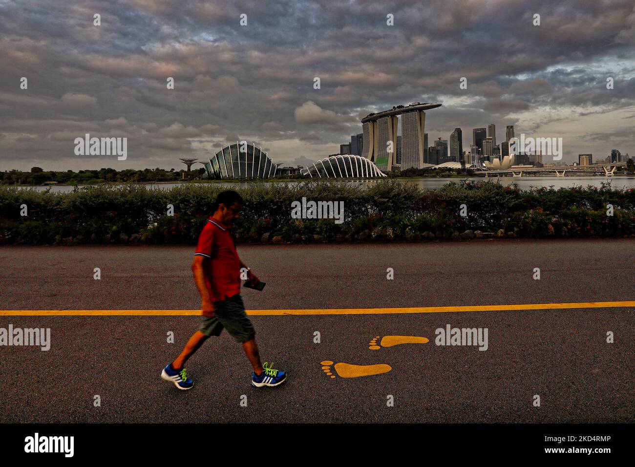 A man brisk walk along the bayfront with the city skyline pictured in ...