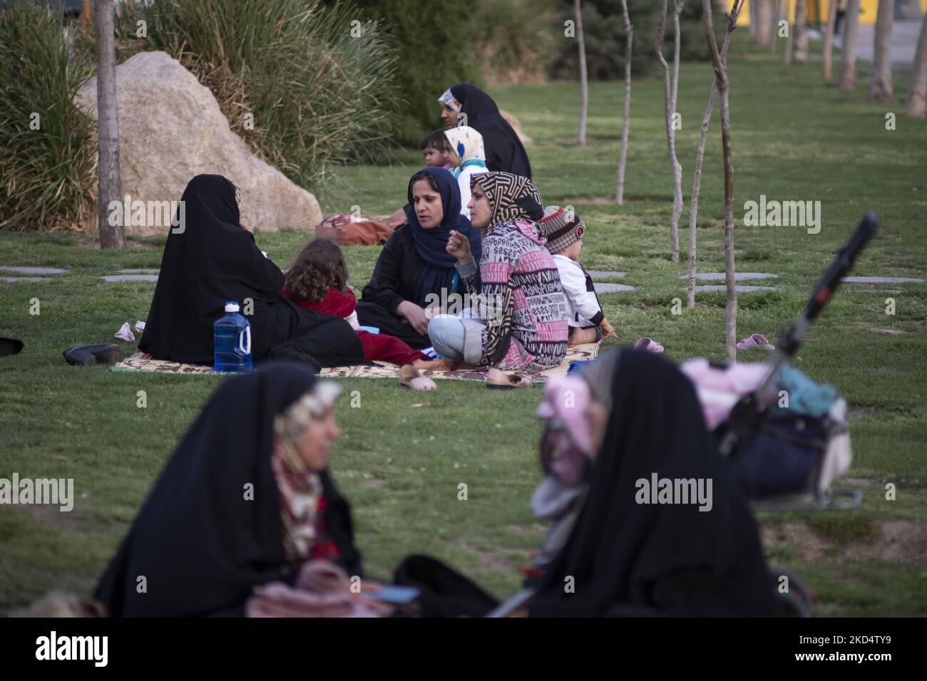 Iranian women sit on a street-side in the holy city of Qom 145Km (90 ...