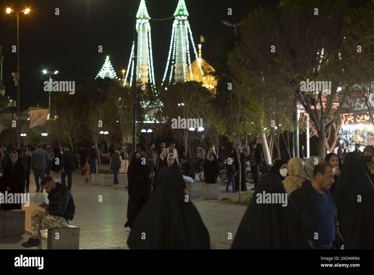 People walk along a pedestrian street near a holy shrine in the holy ...