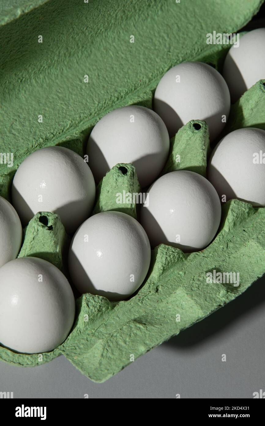 Cardboard green egg box on a gray background, a lot of eggs are in the ...