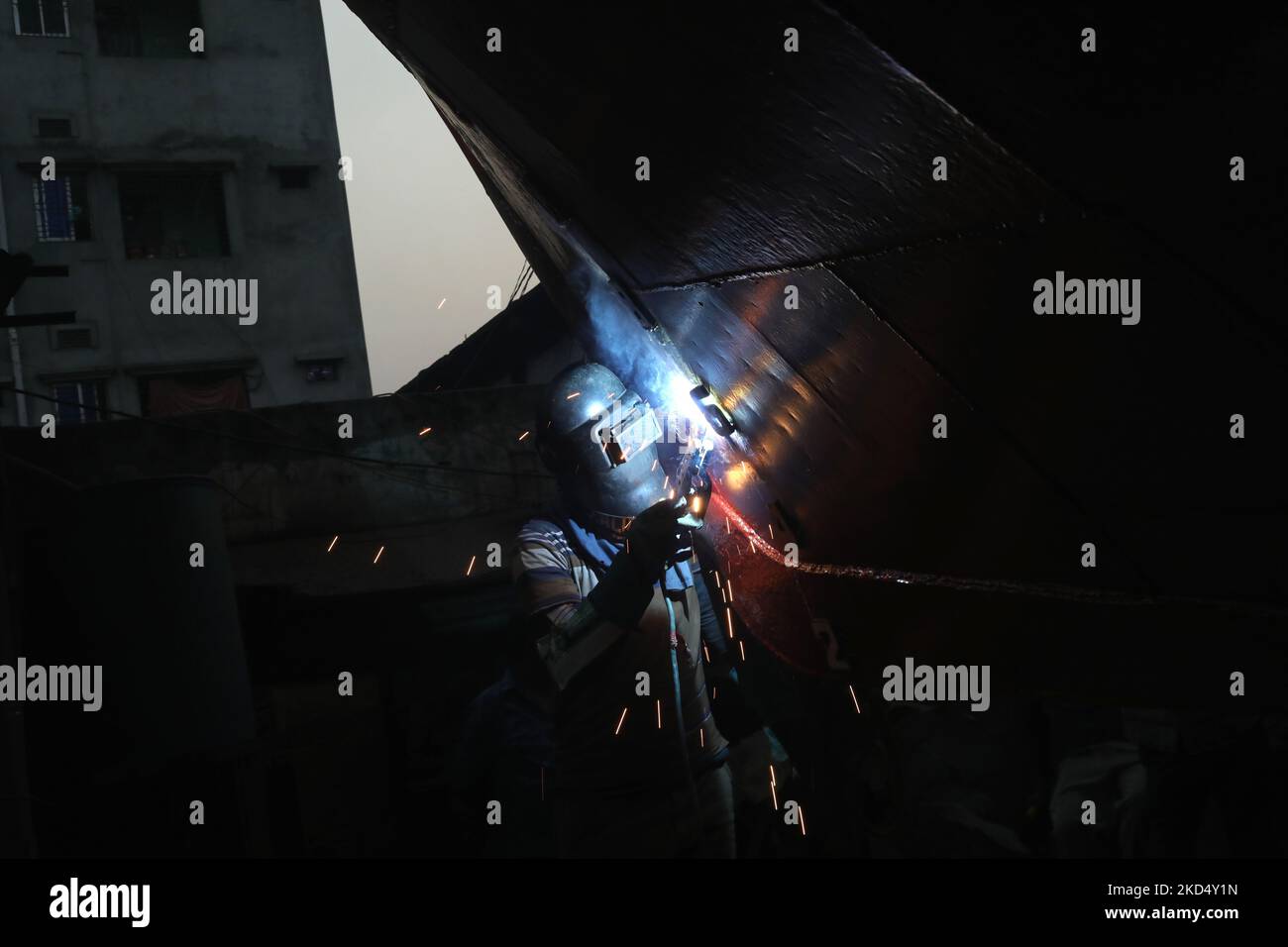 A laborer works at a shipyard on the bank of the Buriganga River in ...