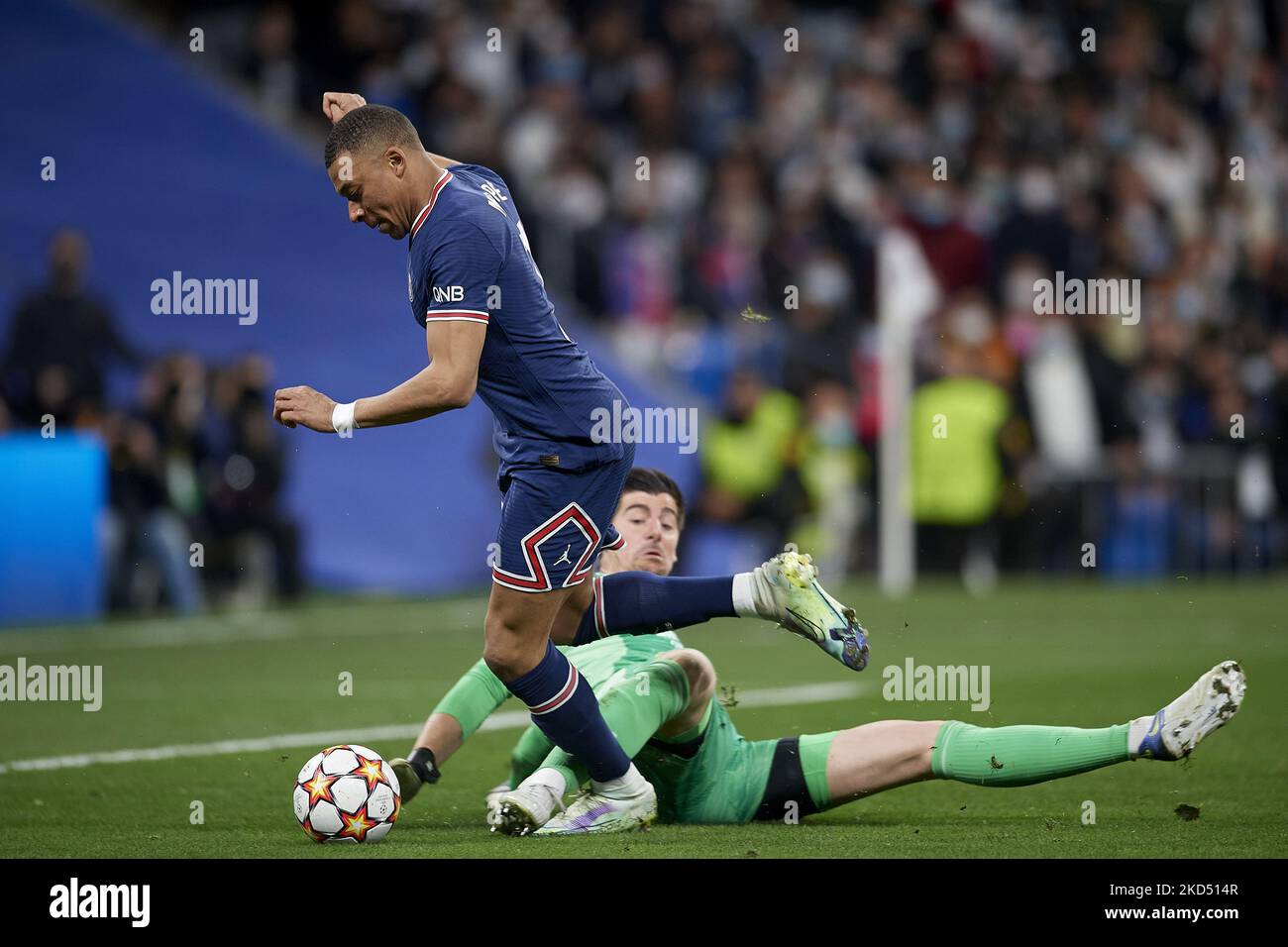 Kylian Mbappe of PSG and Thibaut Courtois of Real Madrid compete for ...
