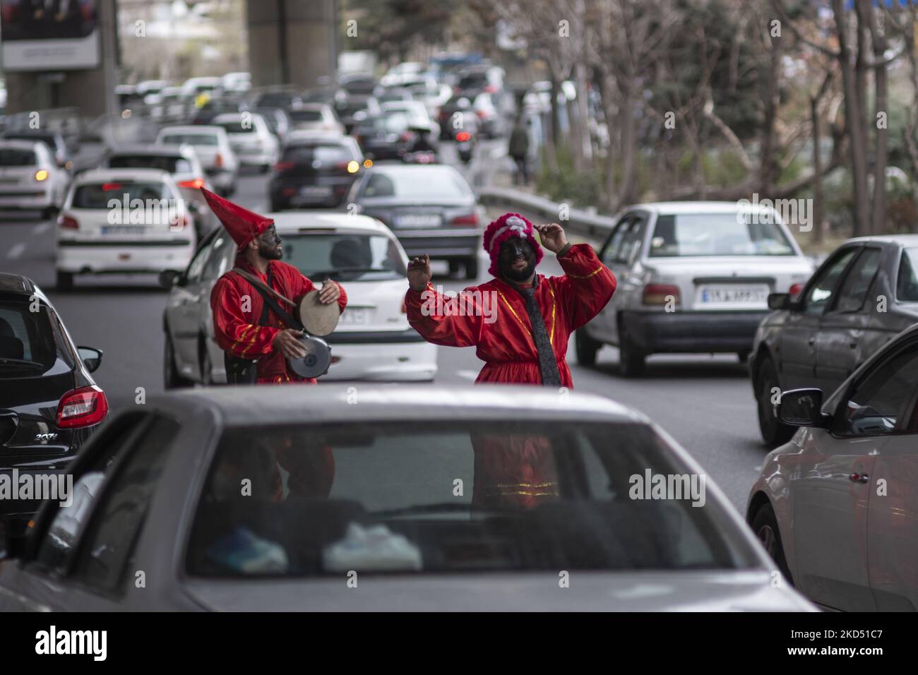 Two Iranian men painted their faces in black and wear red dresses as ...