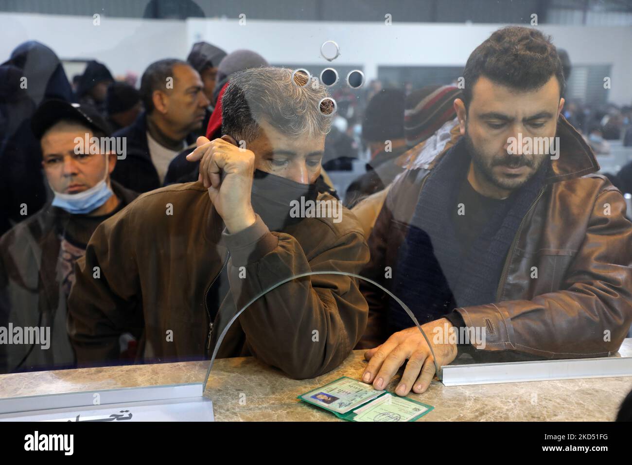 Palestinian policemen check the identity of workers leaving Beit Hanun ...