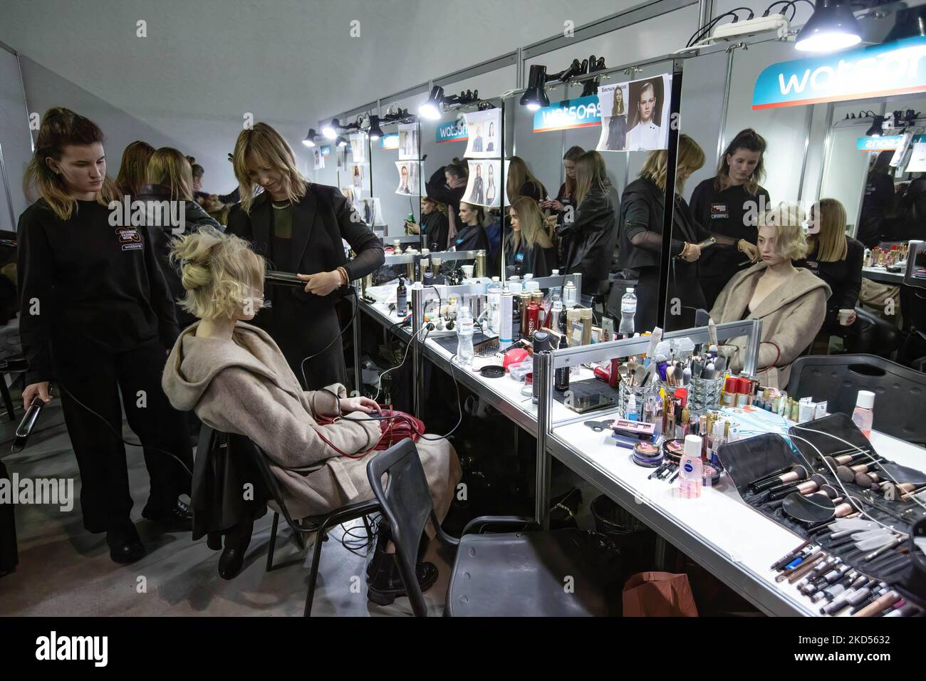 Makeup artists styling a model's hair backstage during the Ukrainian Fashion Week Fall-Winter ...