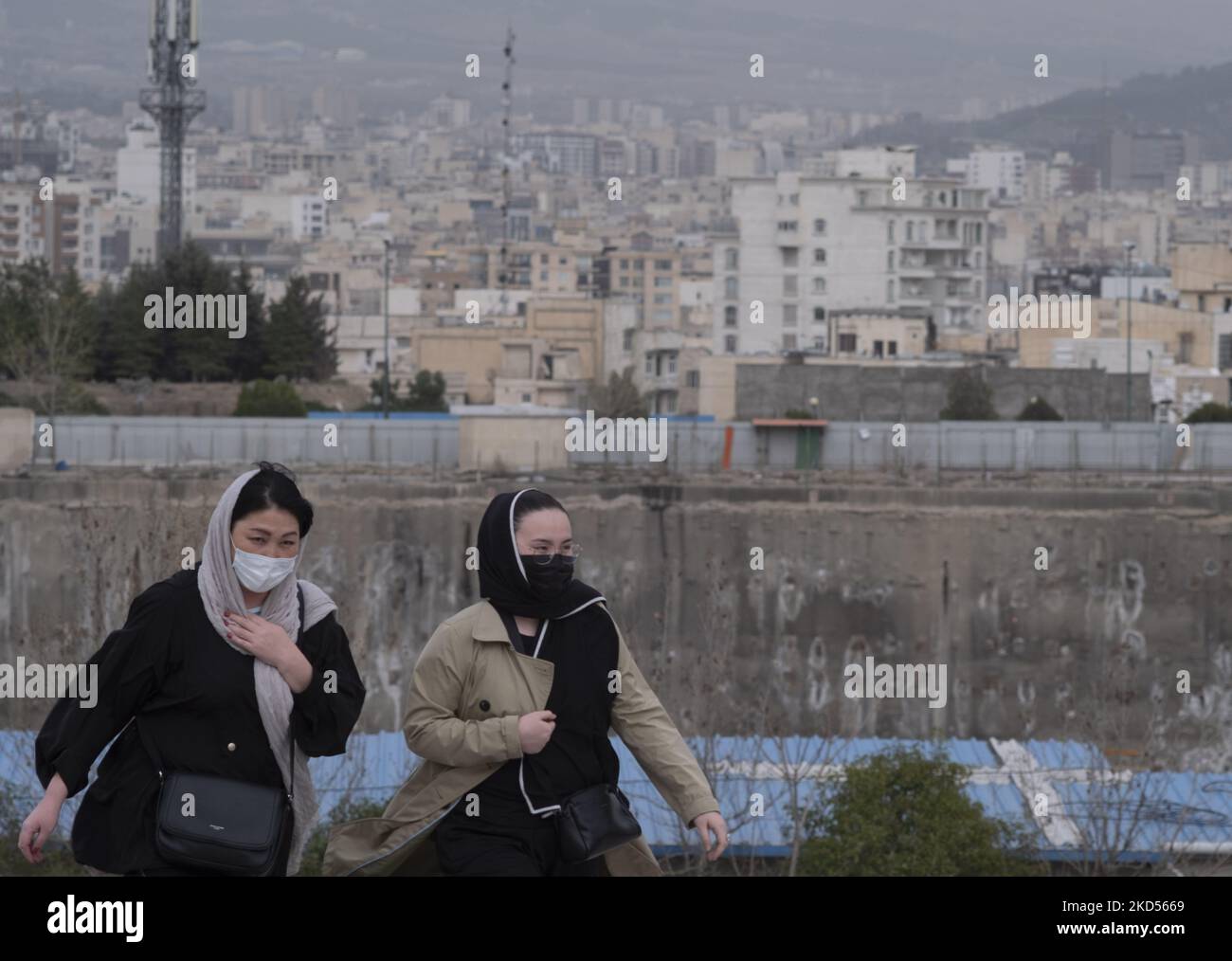 Two Afghan women wearing protective face masks walk along an area ...