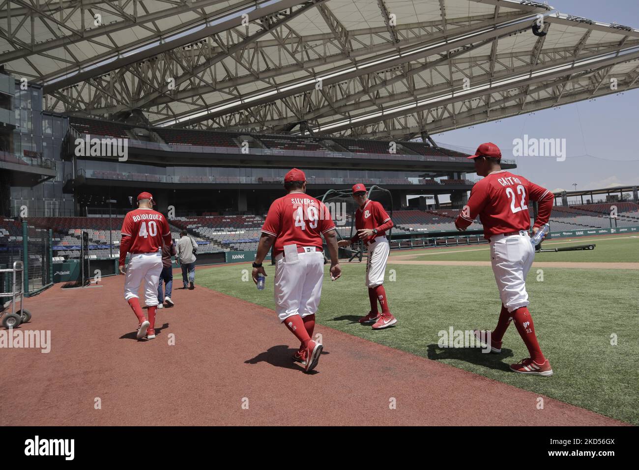 Members of the Diablos Rojos del México team leave the field area at ...