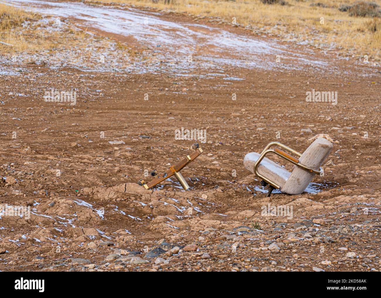 Empty land where broken office chair is stuck in the mud. Land is ...