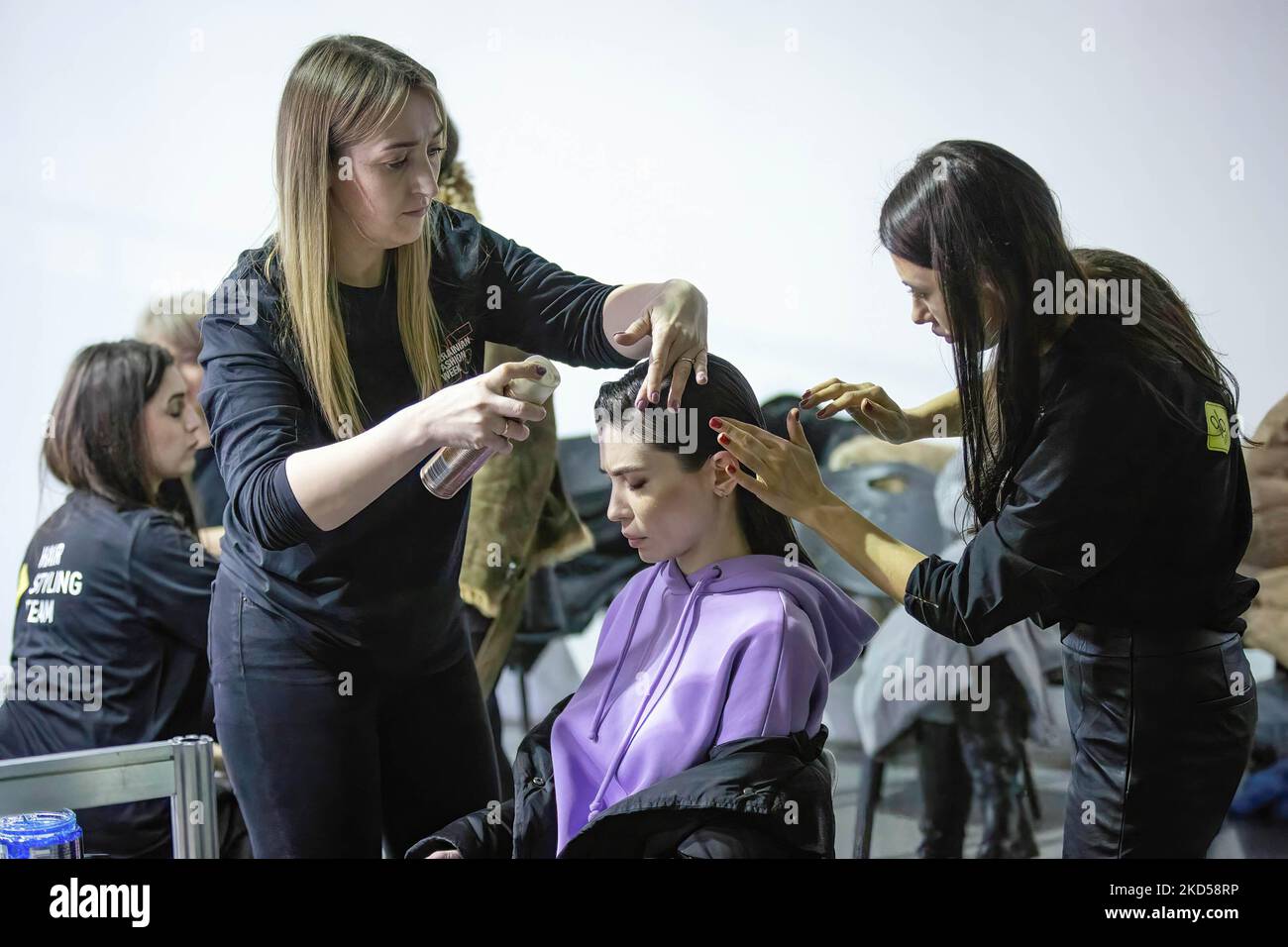 Makeup artists styling a model's hair backstage during the Ukrainian ...