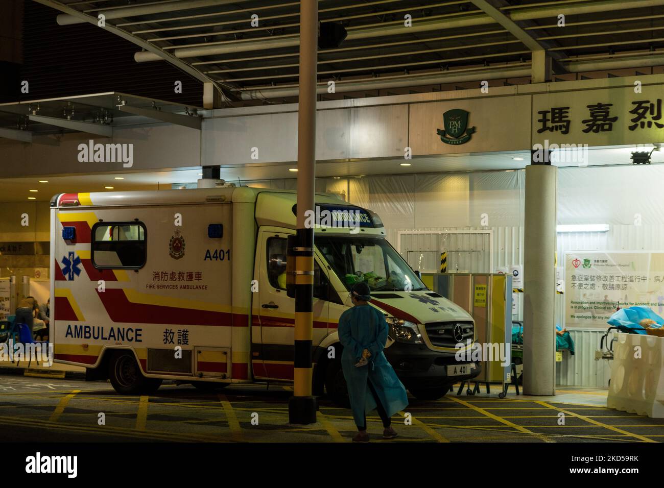 A paramedic in PPE waits for an ambulance near a makeshift triage area ...