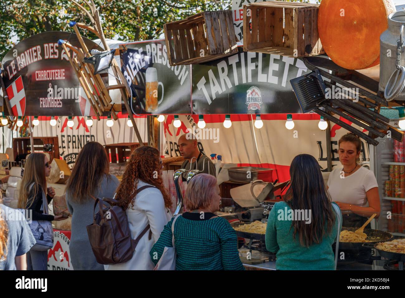 Five people stand in front of a Savoyard stall serving tartiflette and ...