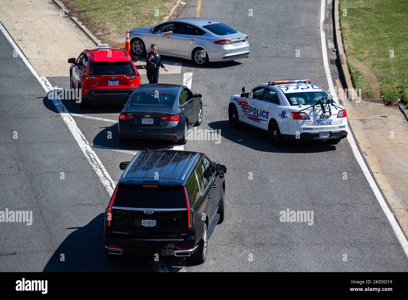 An officer allows a vehicle to pass as police block entrance ramps and ...