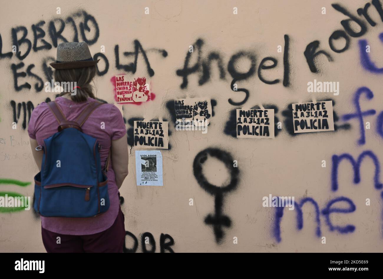 A woman looks at a wall with graffiti related to feminism, in Merida ...