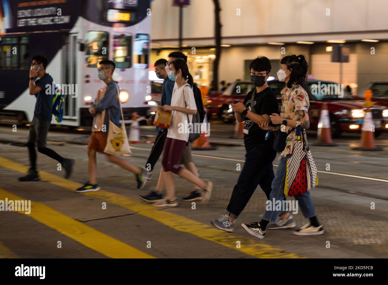 Masked people cross the street in Causeway Bay, in Hong Kong, China, on ...