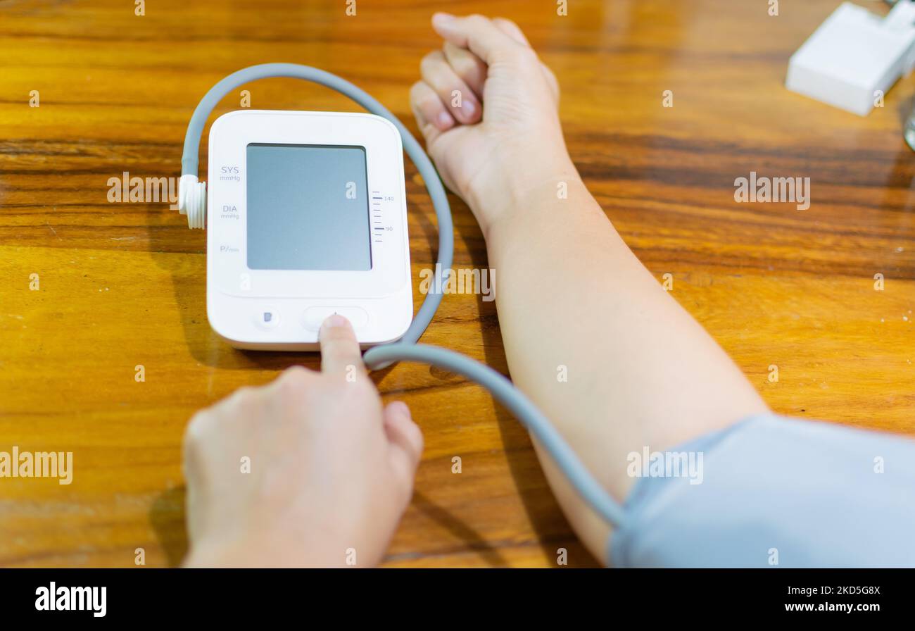 young woman measuring blood pressure and heart rate at home Stock Photo ...