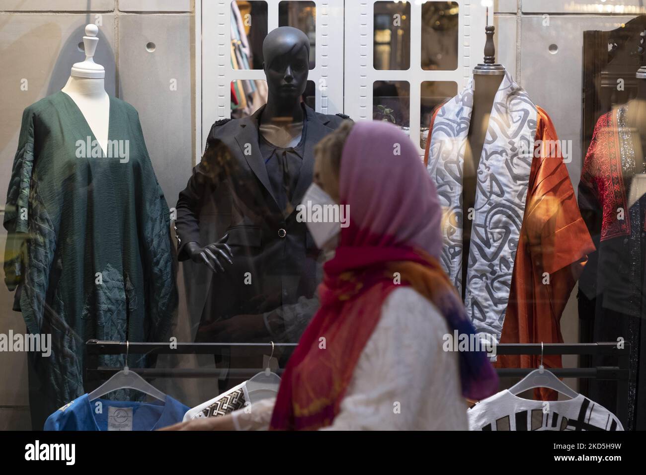 An Iranian woman walks past a shop window in a shopping center during ...