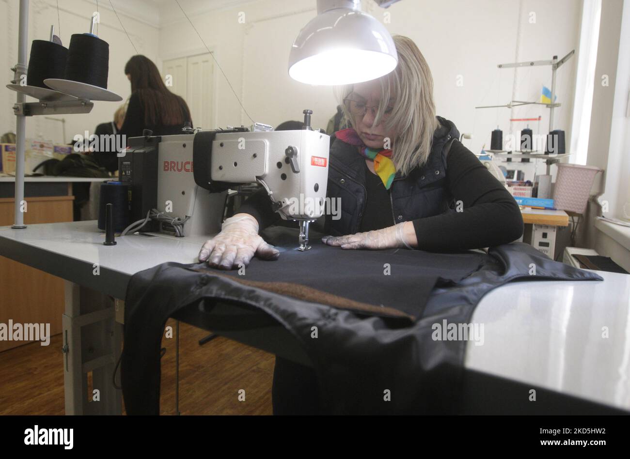 A woman works on bulletproof vests for servicemen of Ukrainian army in ...