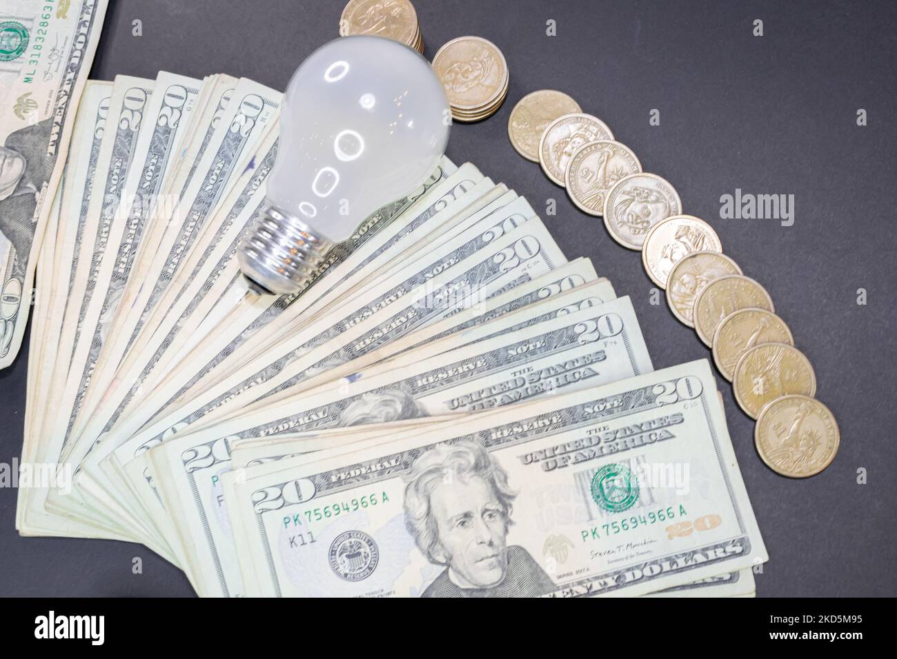 dollar bills and coins with a spotlight. expensive energy Stock Photo ...
