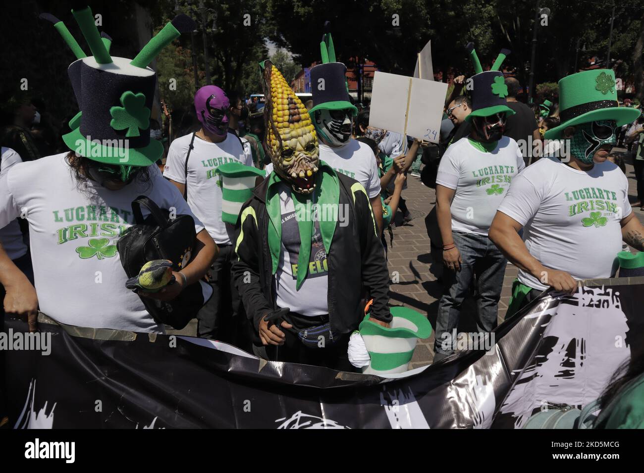 A group of people wearing masks outside the Parish of San Juan Bautista ...