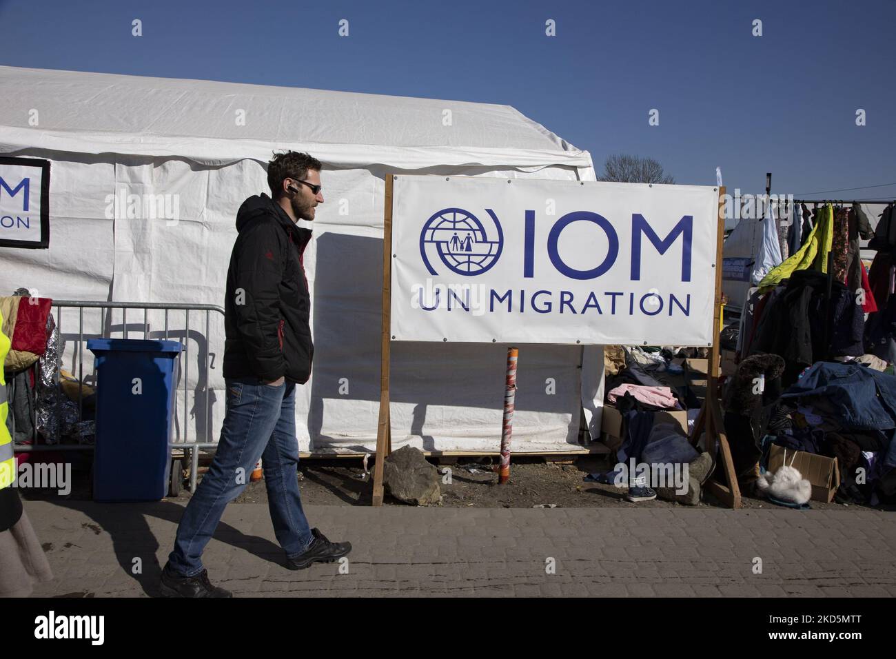 A tent with the IOM logo - UN Migration. Civilian refugees continuously ...