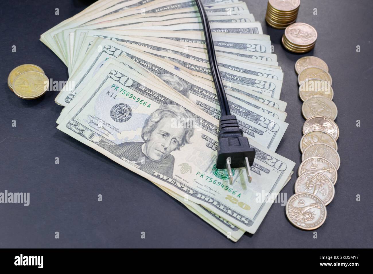 dollar bills and coins with an electric plug. expensive energy Stock ...