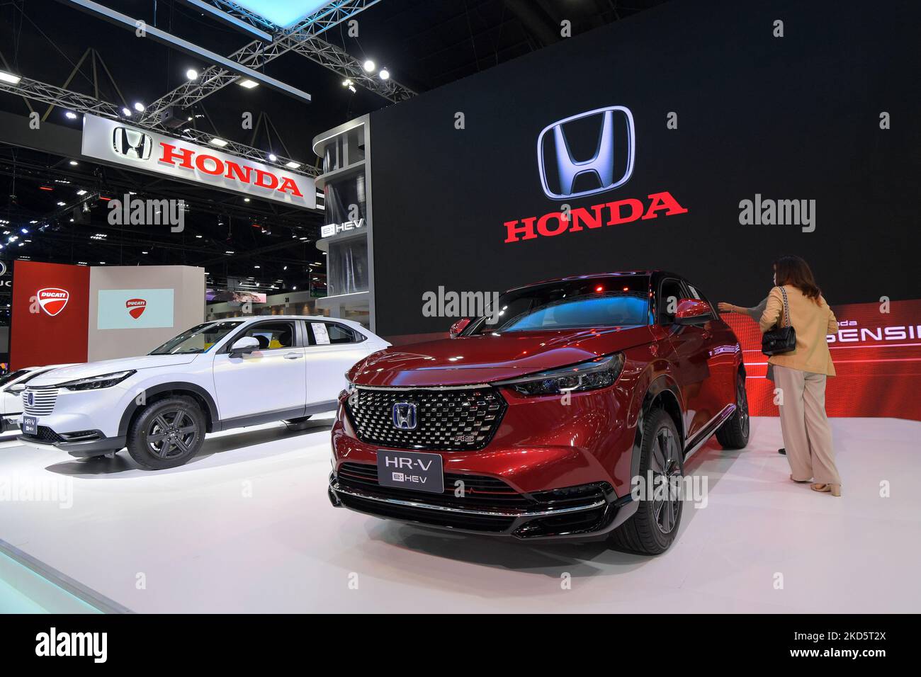 People wearing a face mask take a look at the Honda HR-V e:HEV 2022 ...