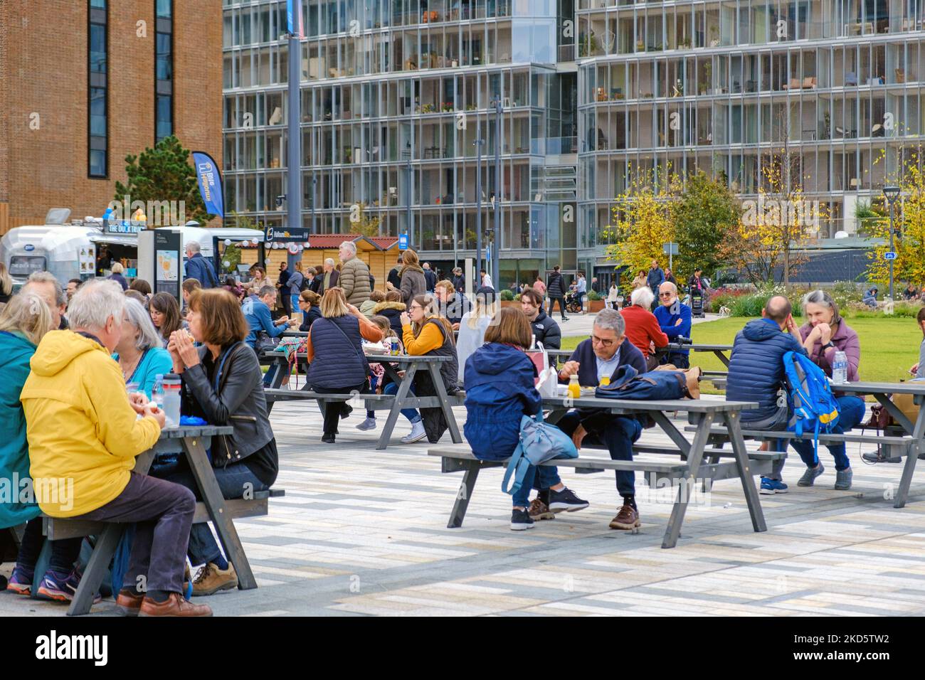 People sit at picnic tables eating street food from The Duck Truck ...